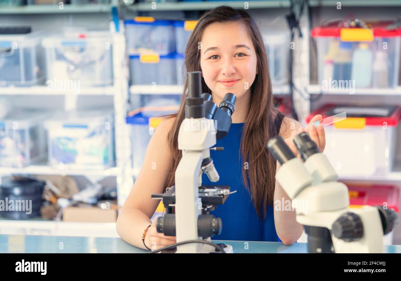 Fille d'école avec un microscope dans le laboratoire. Microscope ...