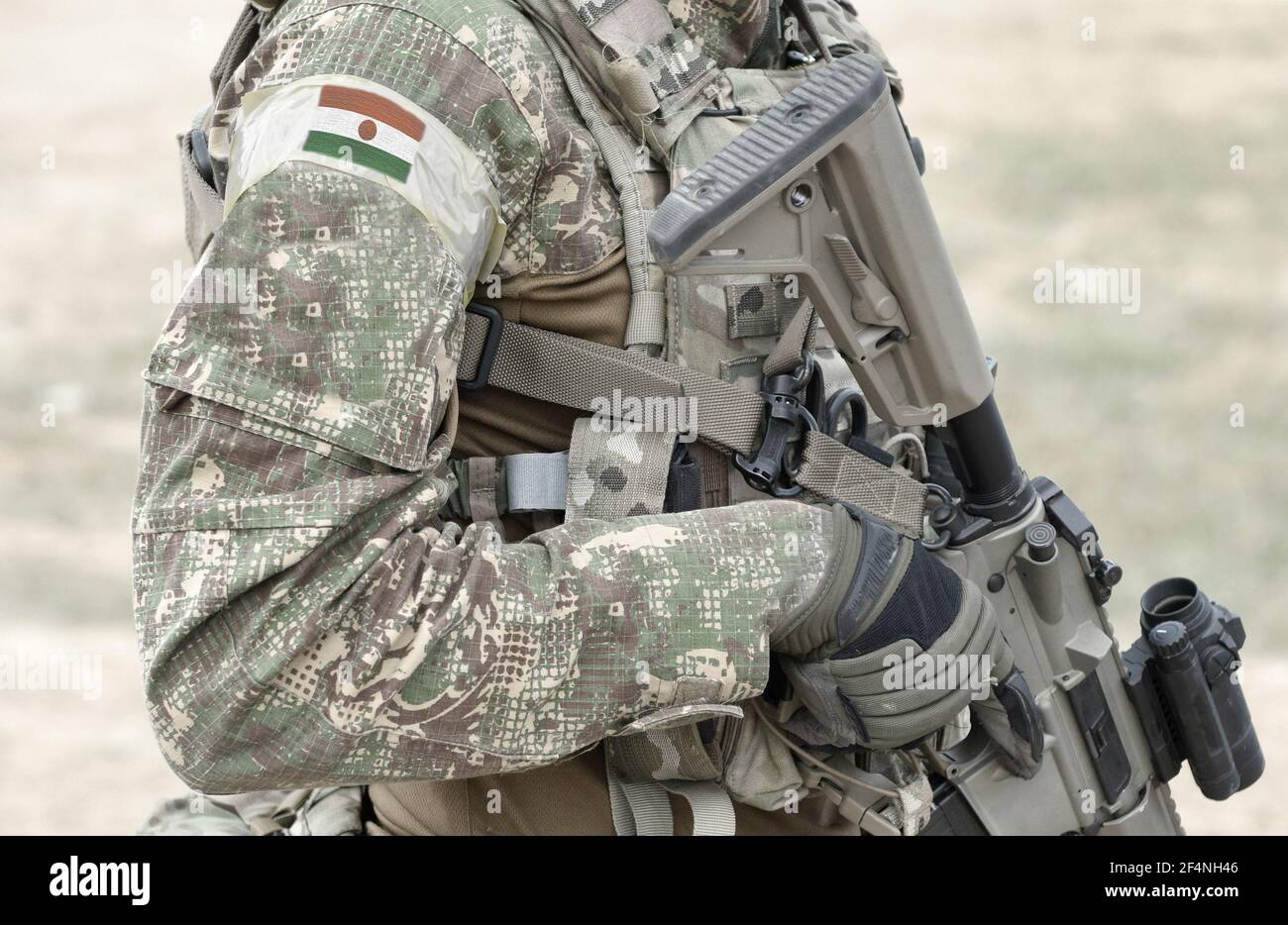 Soldat avec fusil d'assaut et drapeau du Niger sur l'uniforme militaire ...