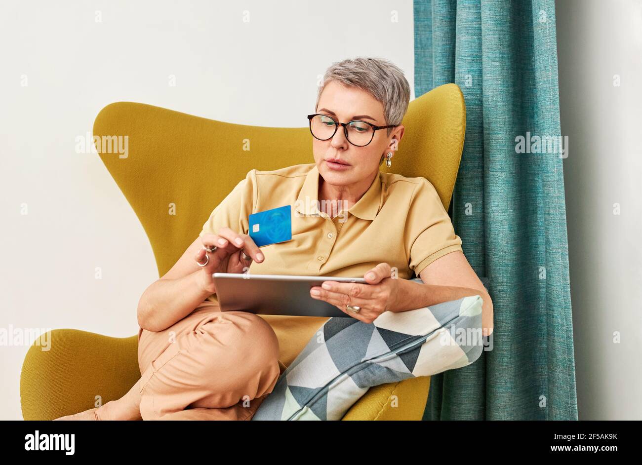 Femme mature assise dans un fauteuil Banque de photographies et d’images à haute résolution - Alamy
