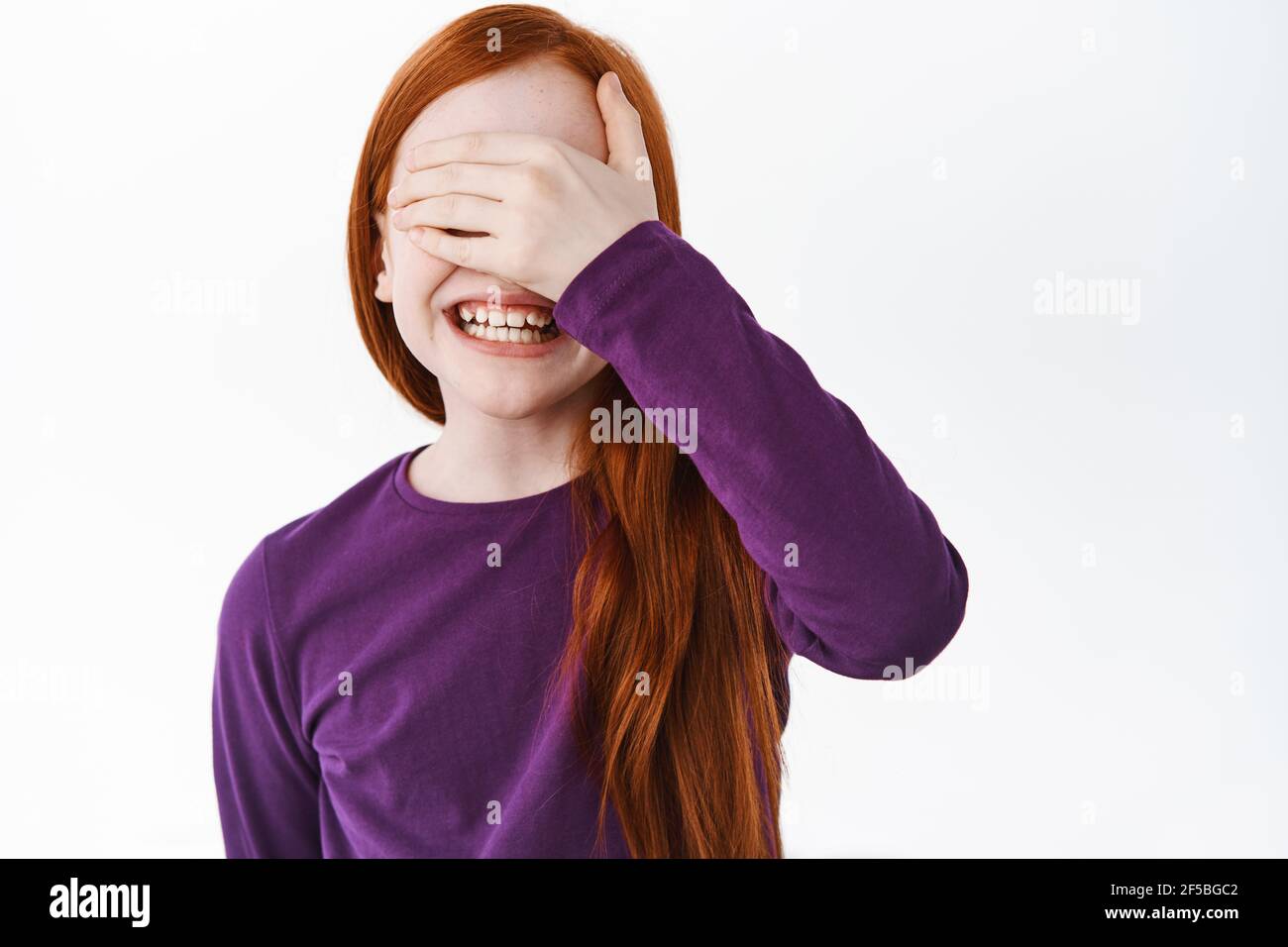 Une petite fille positive aux cheveux rouges et aux taches de rousseur ...