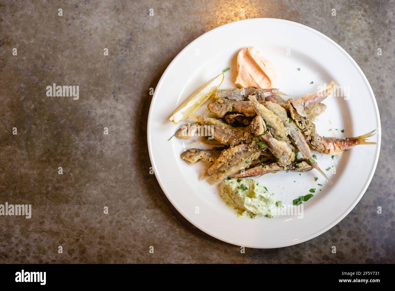 Poisson frit au capelan avec herbes et sauce citron et crème. Plat à ...