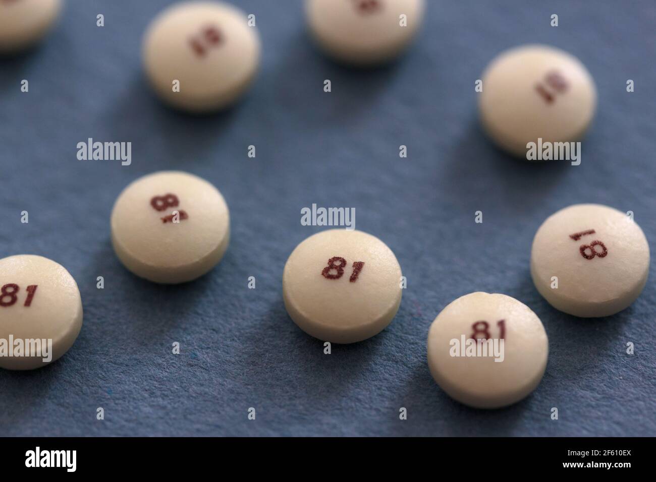 aspirine à faible dose dispersée de 81 milligrammes sur un fond gris ...