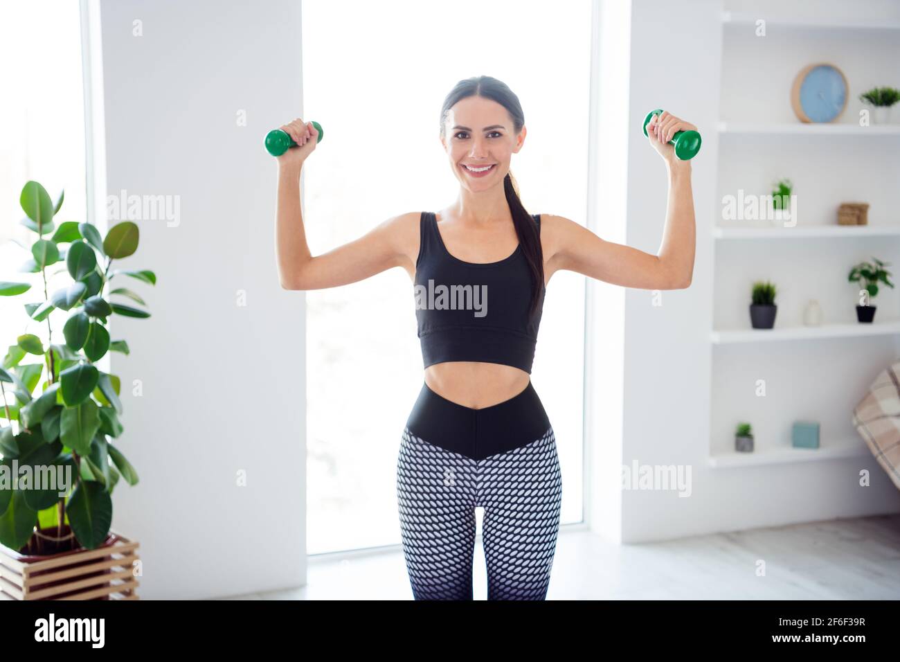 Photo de la jolie personne gaie bras tenir lever des haltères en terre ...