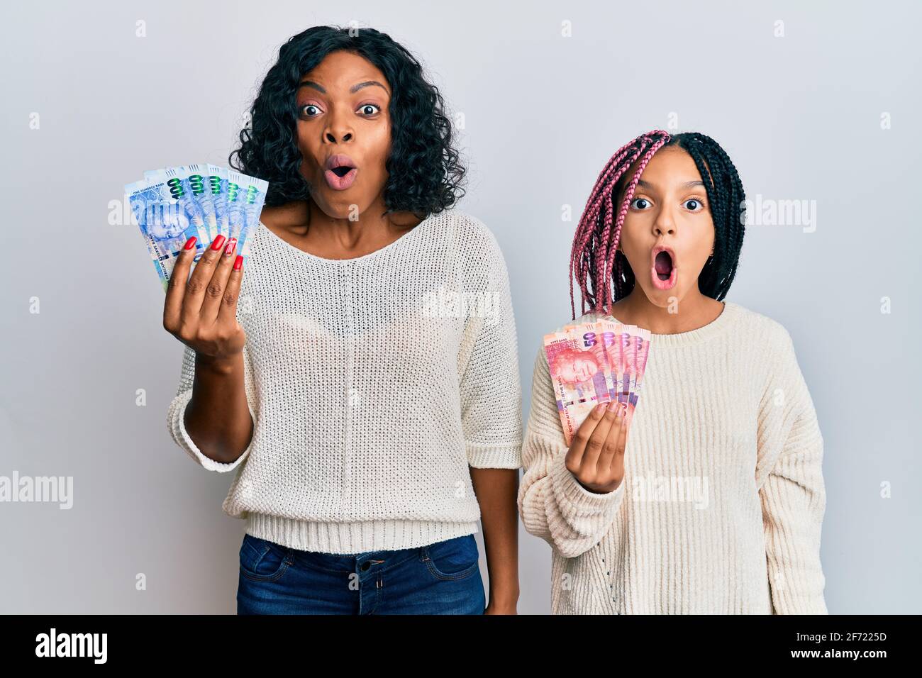 Belle mère et fille afro-américaine tenant des billets de rand sud ...