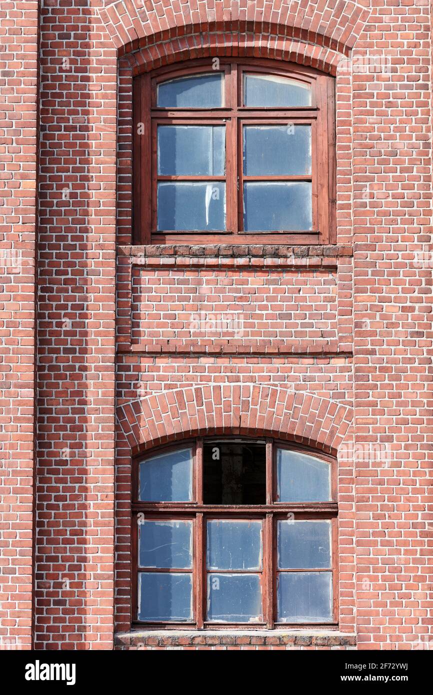 Deux fenêtres voûtées en verre sont fixées dans un mur de briques ...