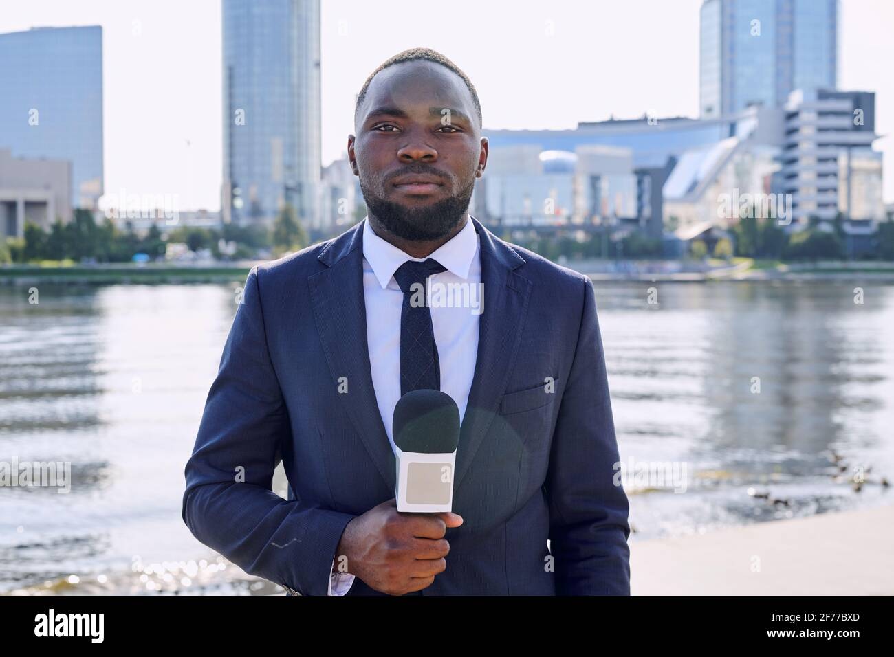 Jeune journaliste confiant ou journaliste d'origine africaine tenant un ...