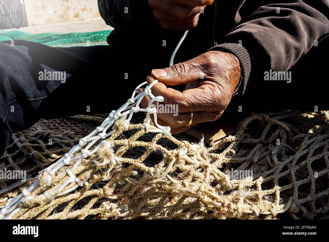 le vieux pêcheur fait la main sur la jetée pour y jeter un filet de ...