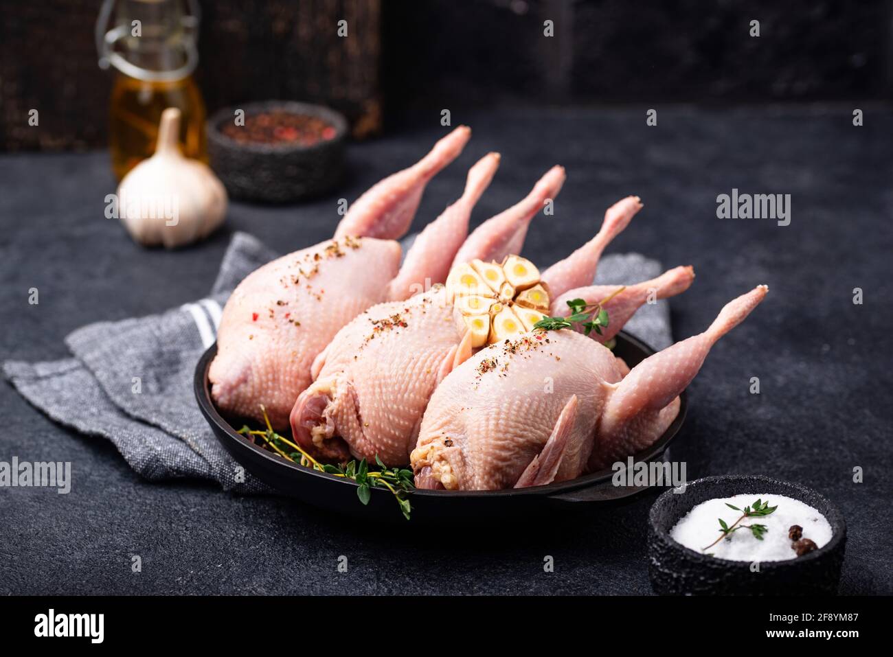 Viande de caille crue aux épices, à l'ail et aux herbes Photo Stock - Alamy