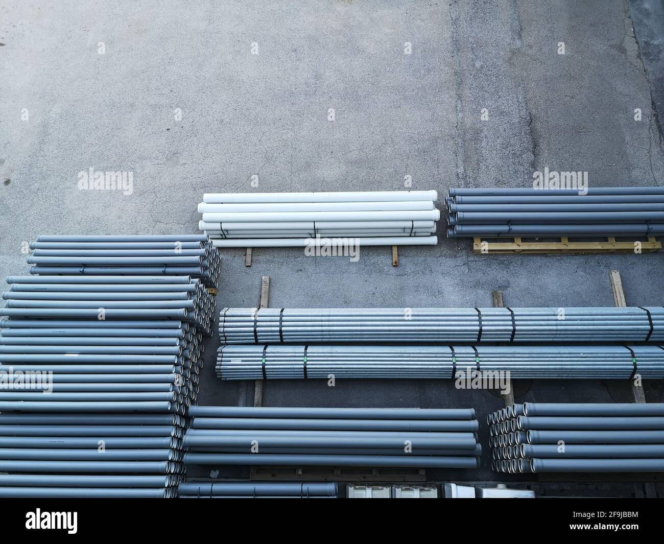Gros plan des profilés métalliques empilés et des tubes contre un mur ...