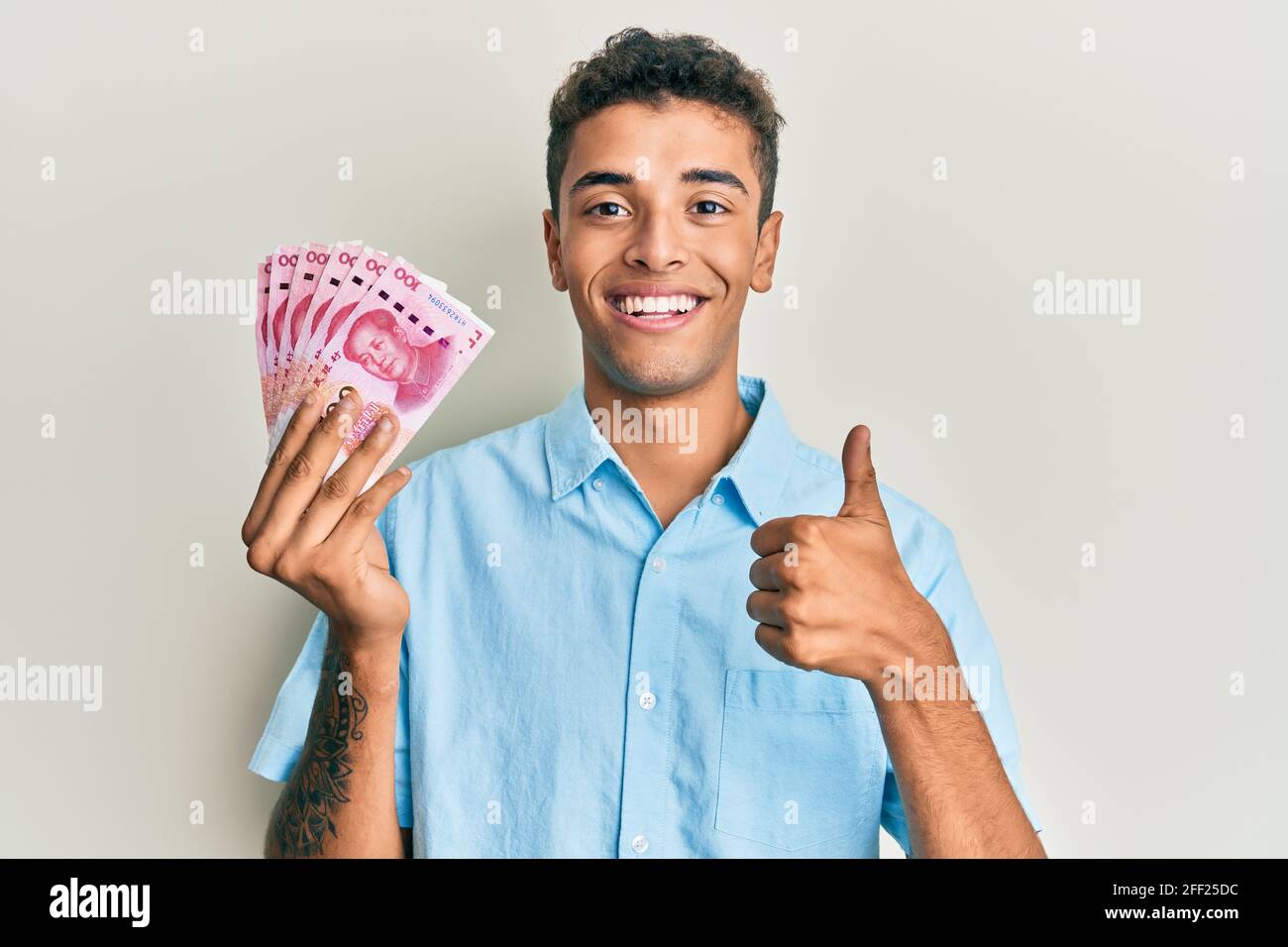 Un jeune homme afro-américain élégant détient 100 yuan de billets ...
