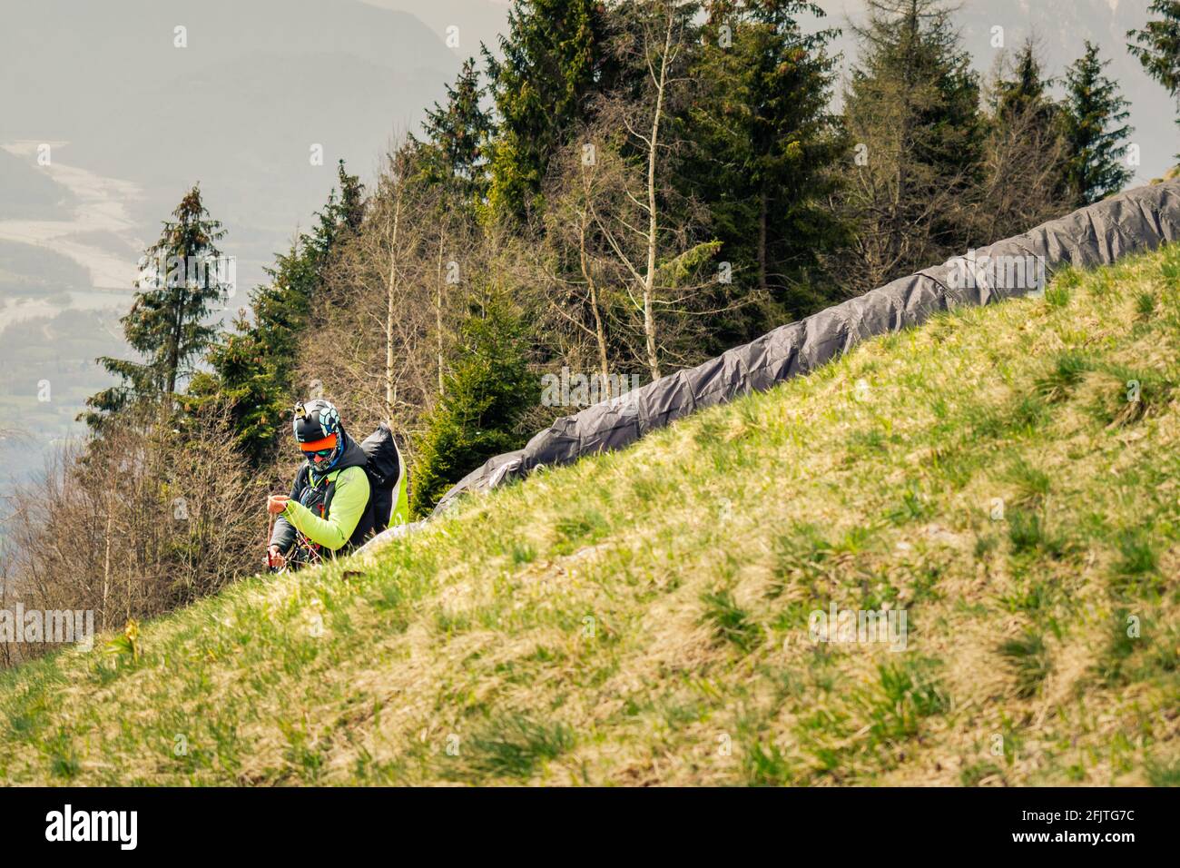 L'homme sur une pente herbeuse prépare le planeur au parapente depuis ...