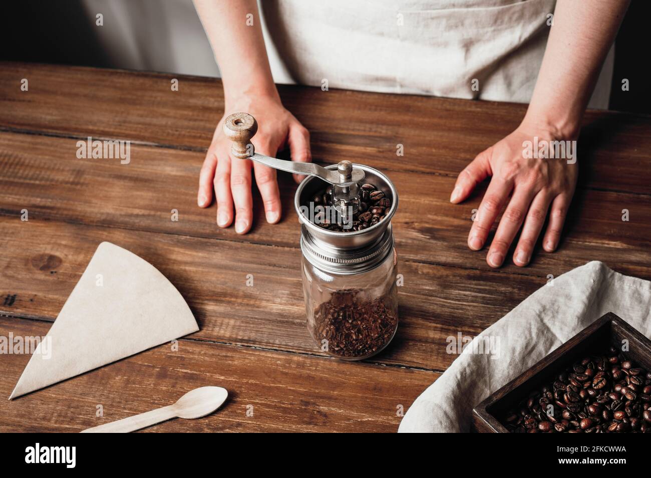 Une table en bois avec une meuleuse manuelle café de métal et le verre ...
