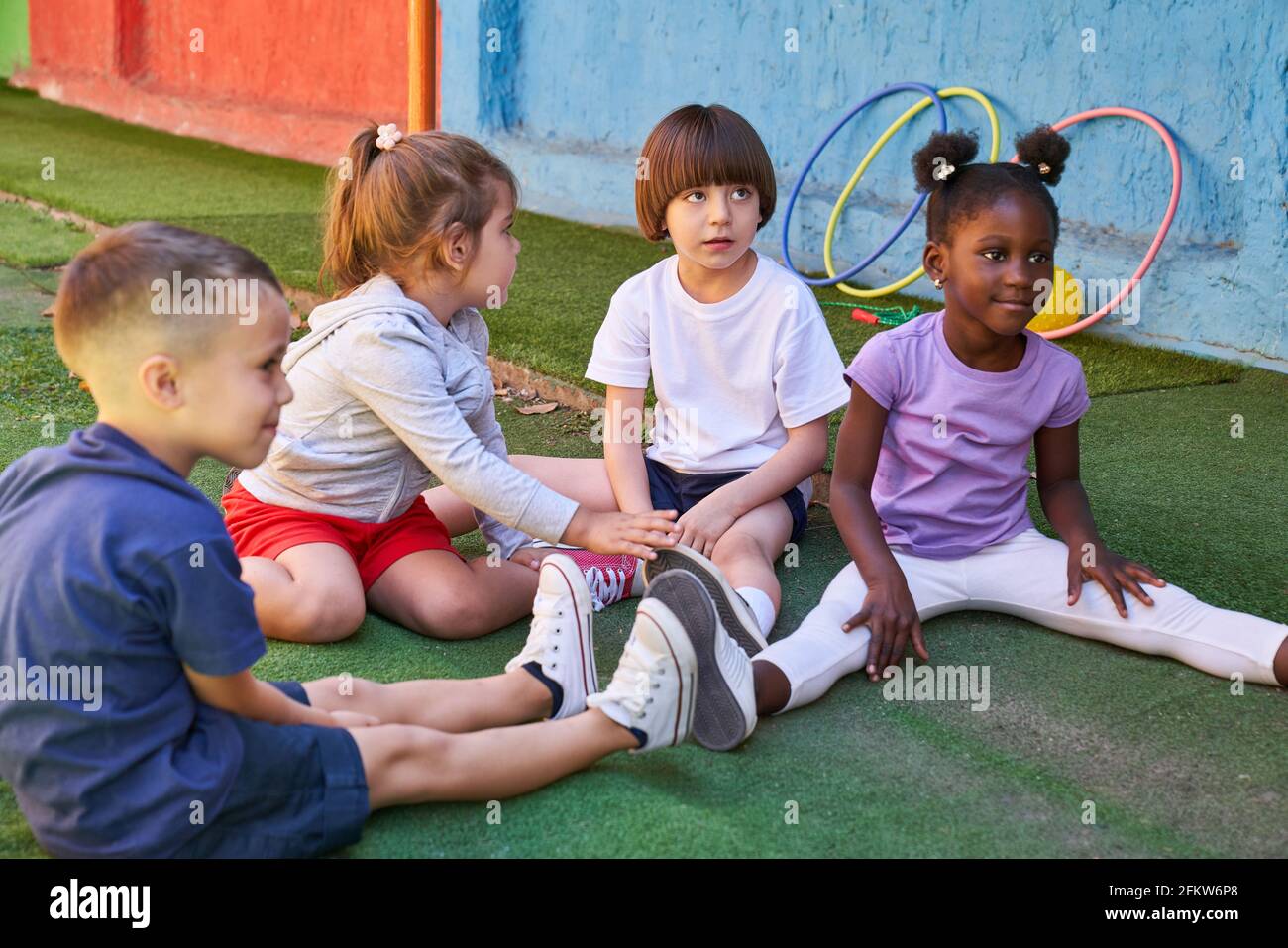 Groupe d'enfants faisant des exercices d'étirement dans la classe d ...