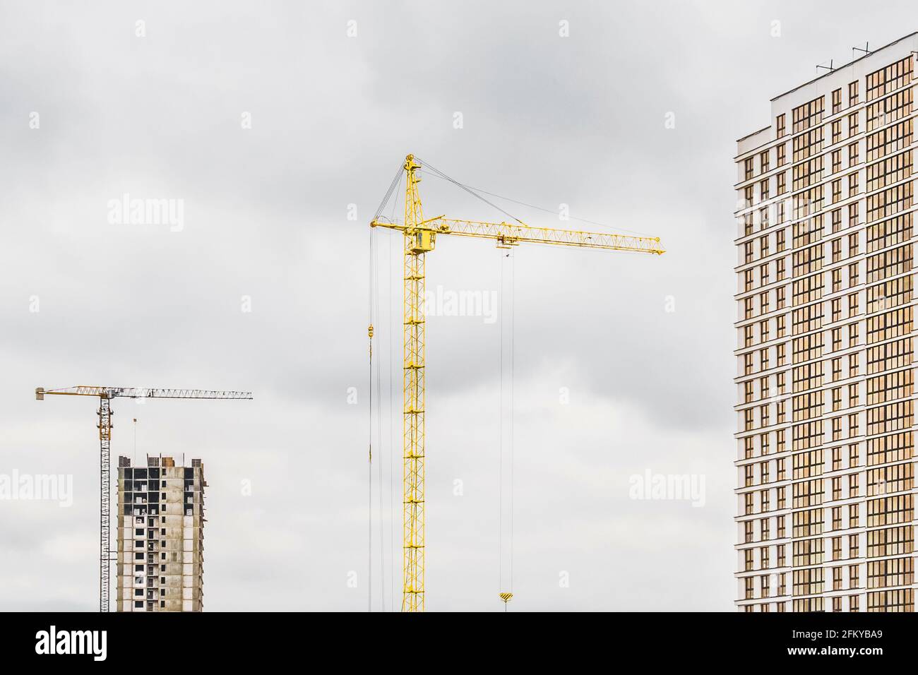 Une grue à tour industrielle construit un nouveau bâtiment moderne de ...