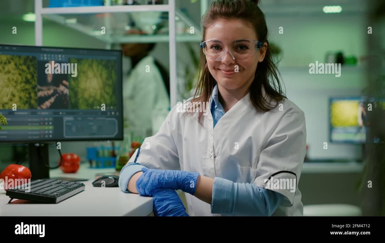 Portrait d'une biologiste souriante analysant un organisme ...