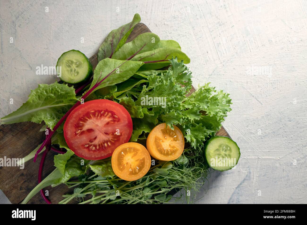 différents types de salades et concombres, tomates rouges et jaunes à ...