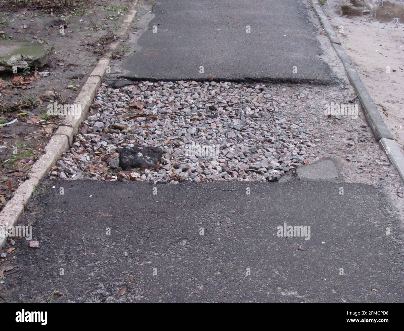 Chemin d'asphalte brisé avec gravier dans les puits Photo Stock - Alamy