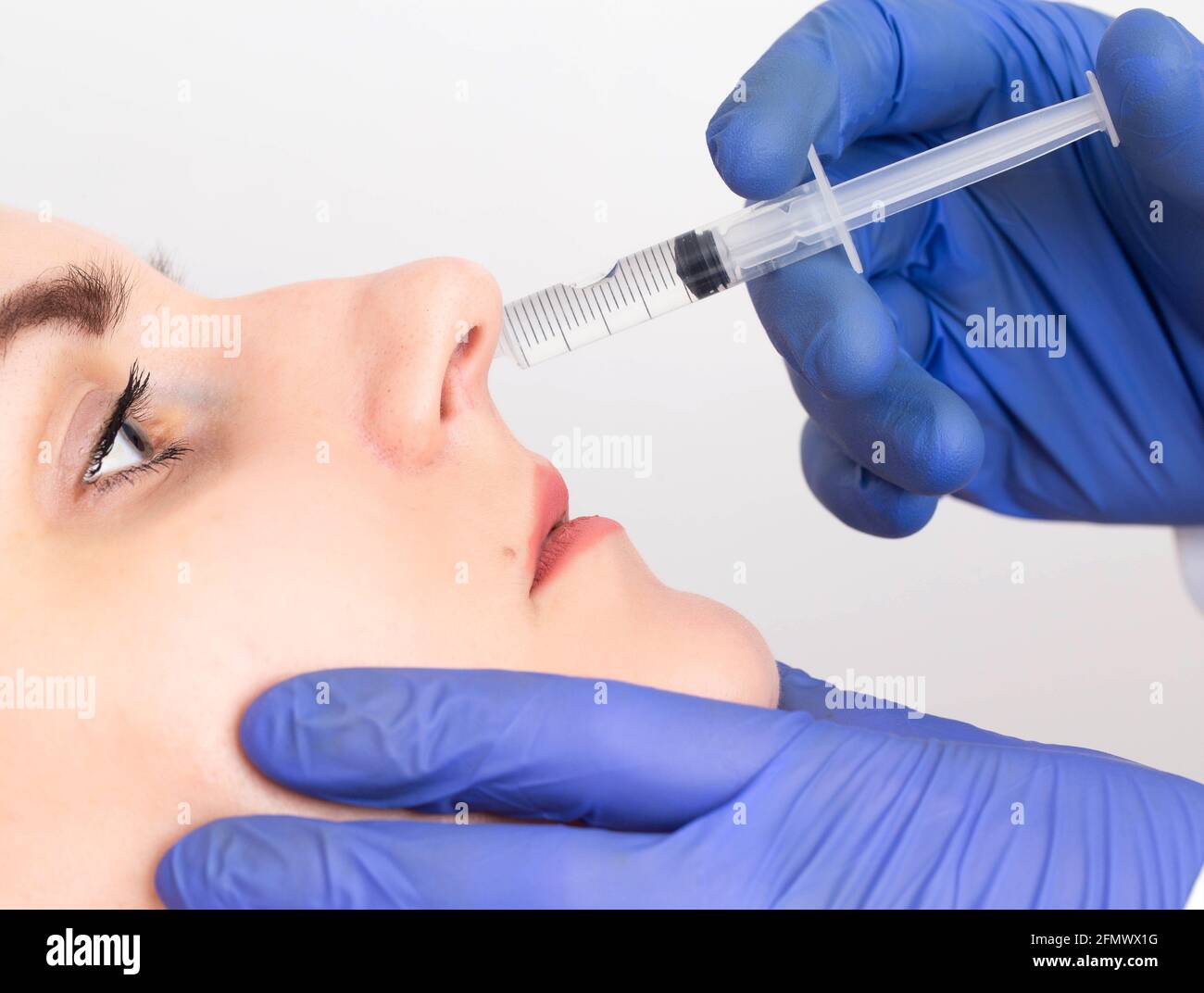 Le médecin fait la procédure à la jeune fille un bloc intranasal, gros ...