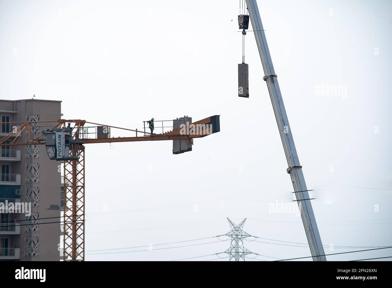 grue de construction construite à l'aide d'une grue secondaire contre ...