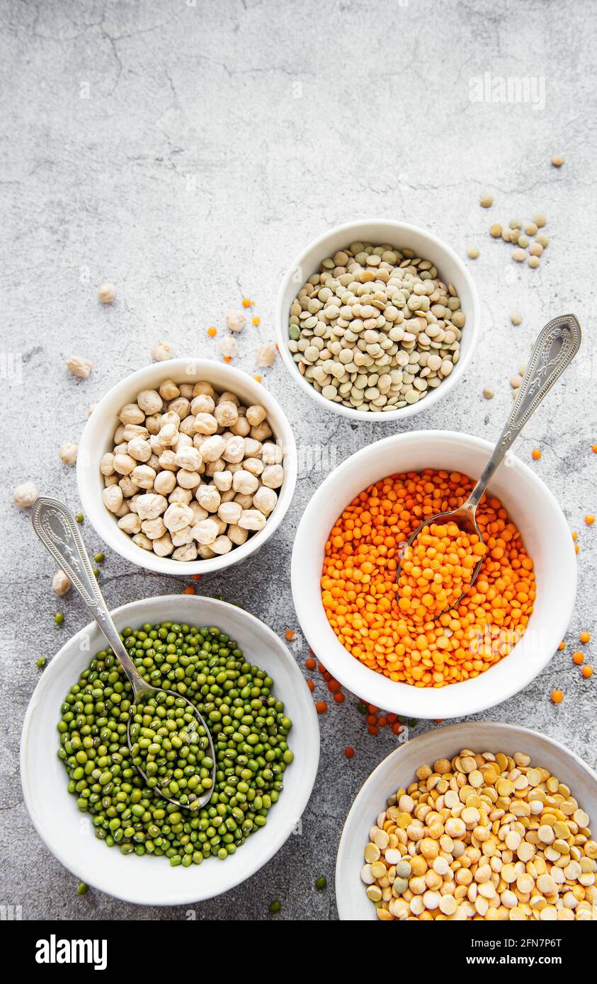 Bols avec différents types de légumineuses sur un béton gris arrière ...