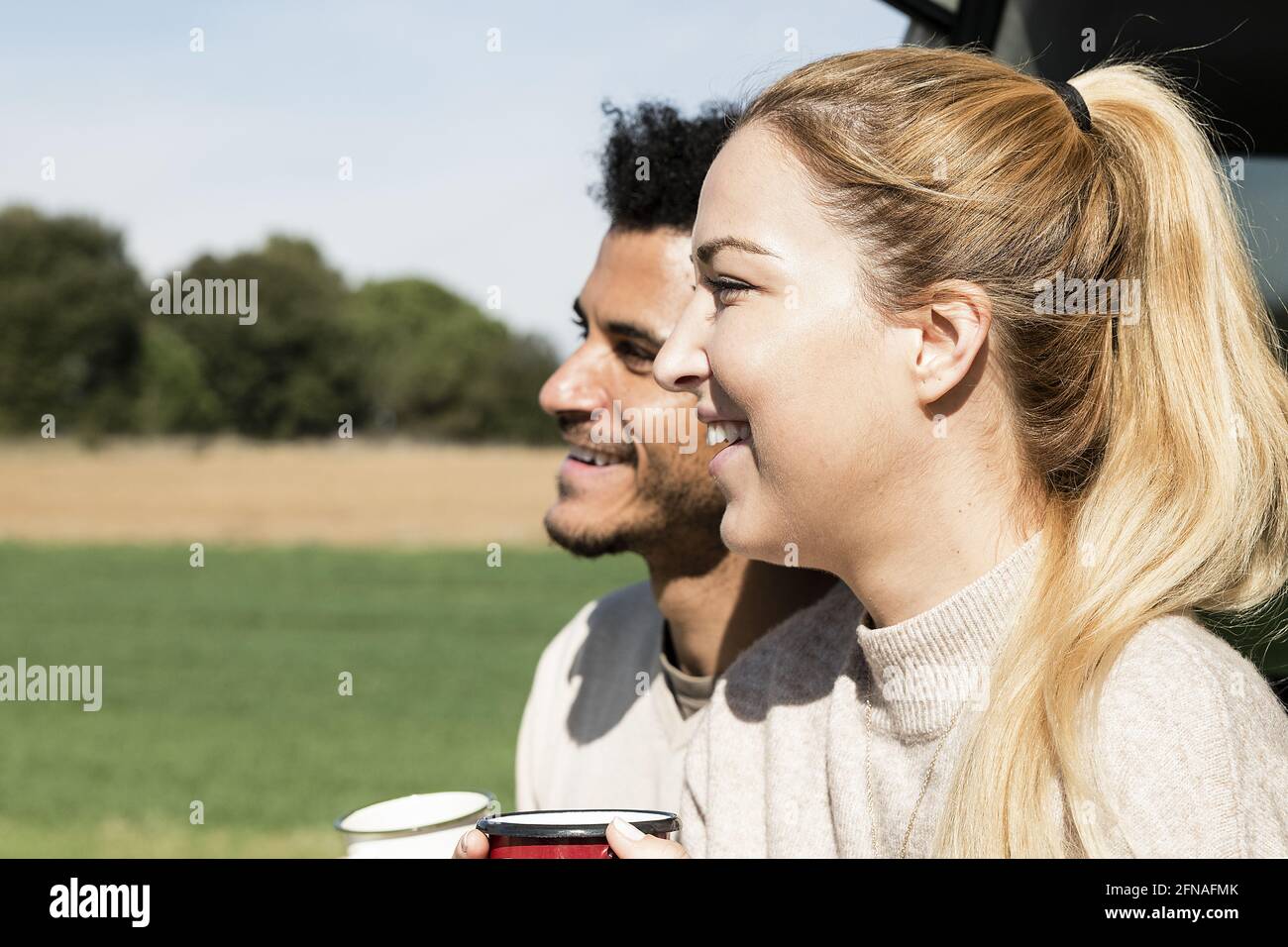 Un jeune couple heureux qui fait une pause-café sur la route voyage à ...