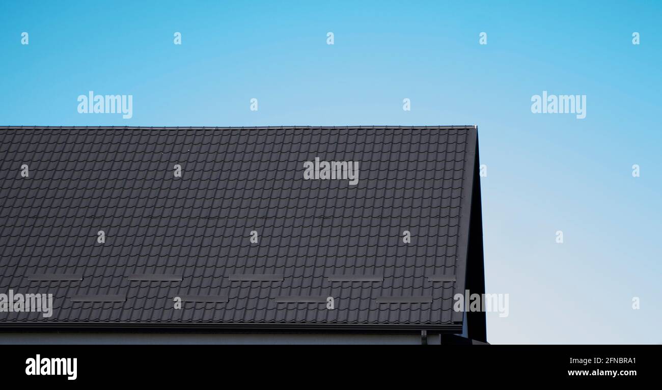 Toit à profil métallique ondulé brun installé dans une maison moderne ...