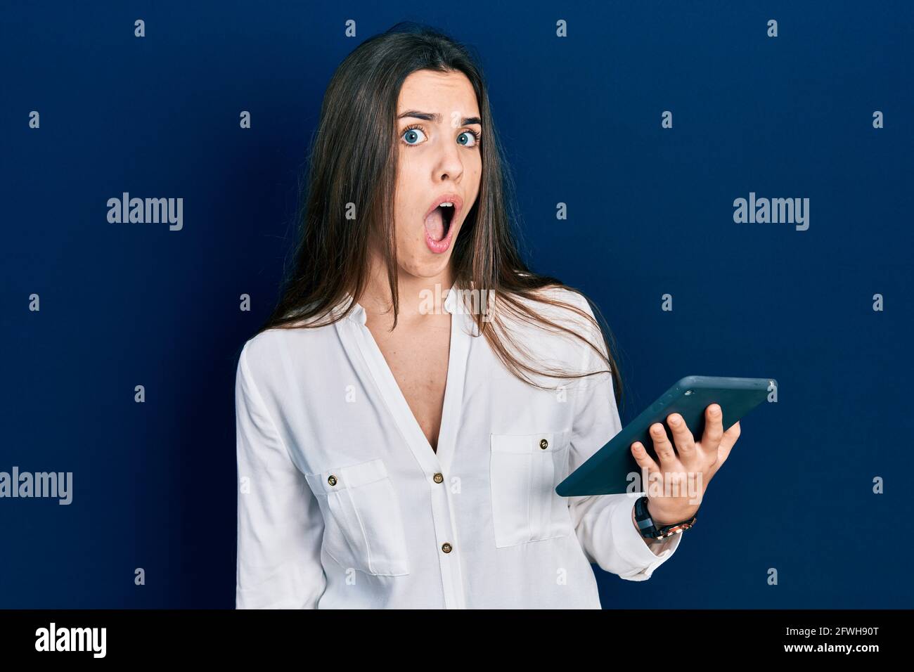 Jeune adolescent brunette utilisant le dispositif de pavé tactile ...