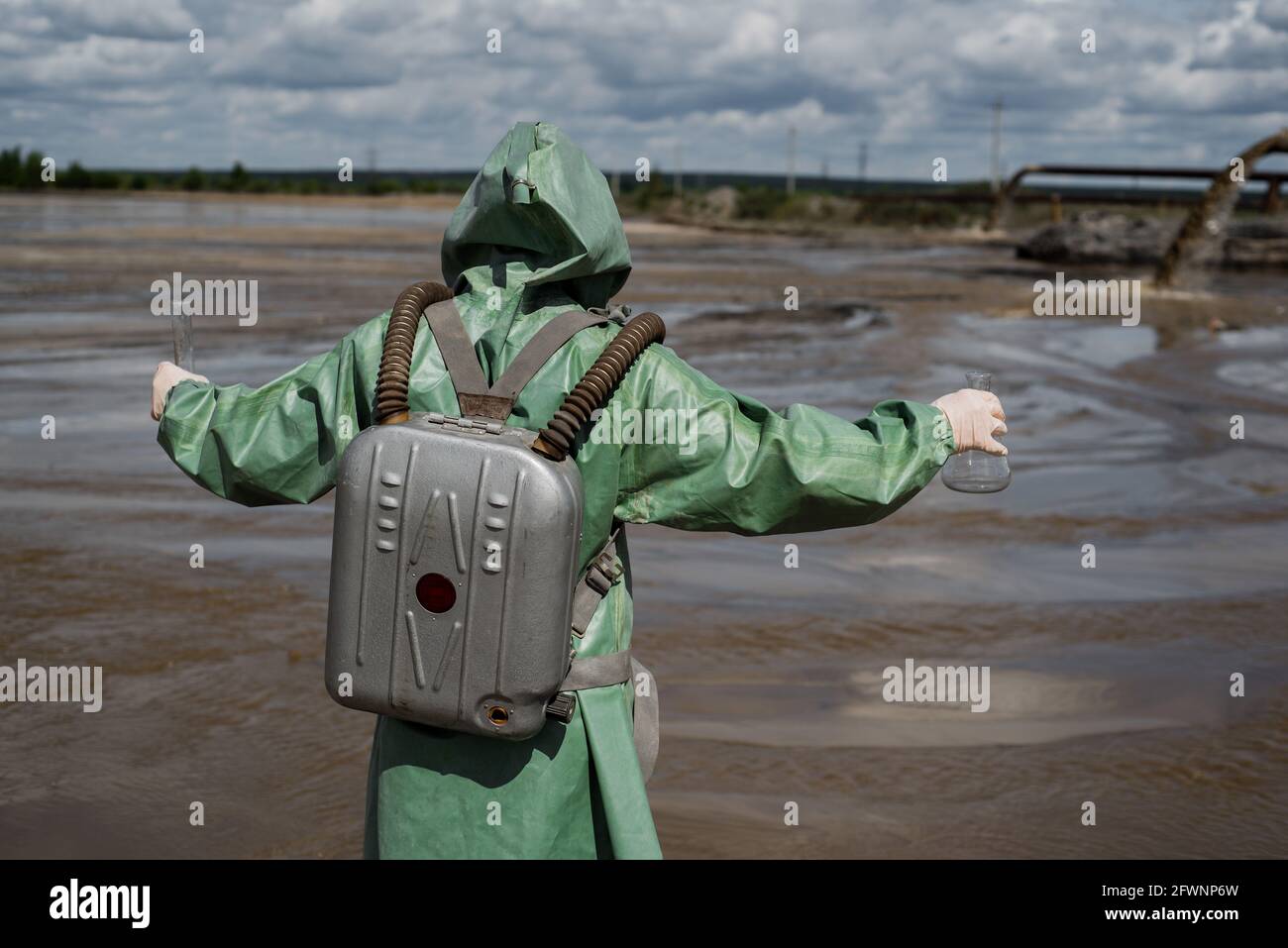 Un écologiste masculin dans un costume de protection vert et un masque ...