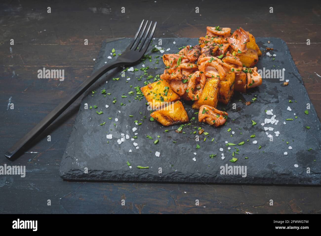 Bébé calamar à l'ail et aux pommes de terre, une entrée typique de la ...