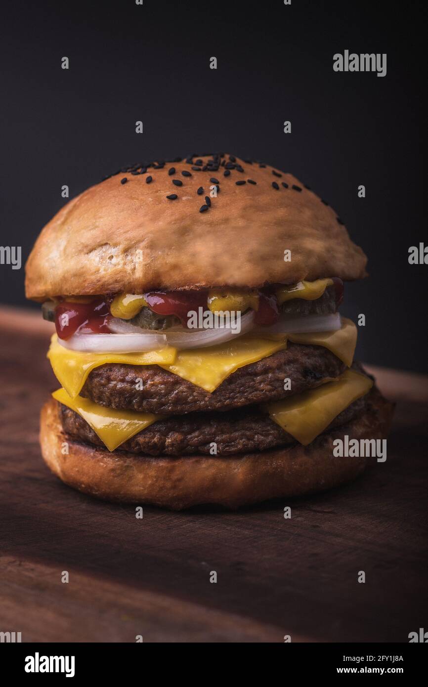 Plan vertical d'un double cheeseburger frais avec des légumes sur une ...