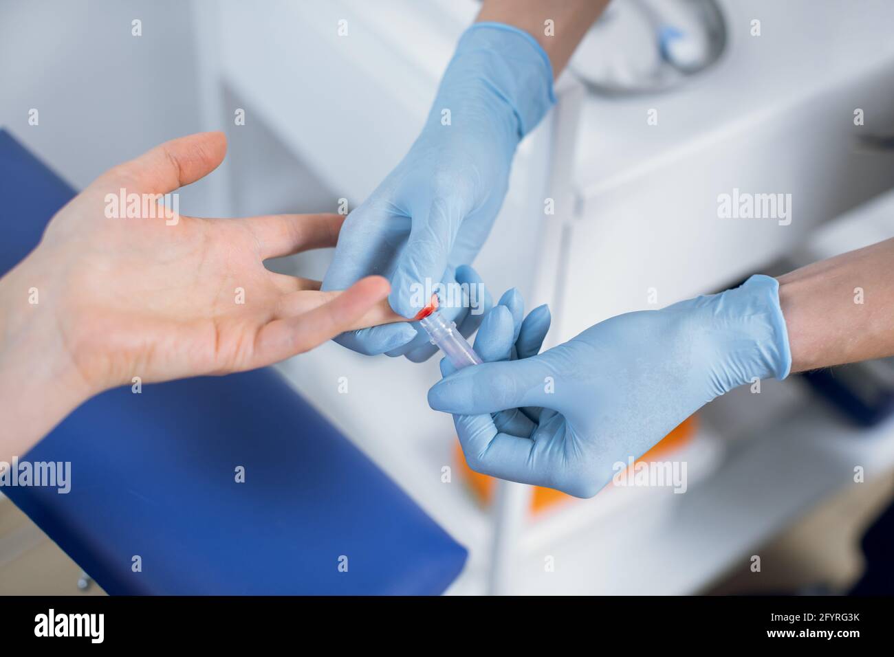 Gros plan des mains du médecin dans des gants, en prenant le sang de la ...