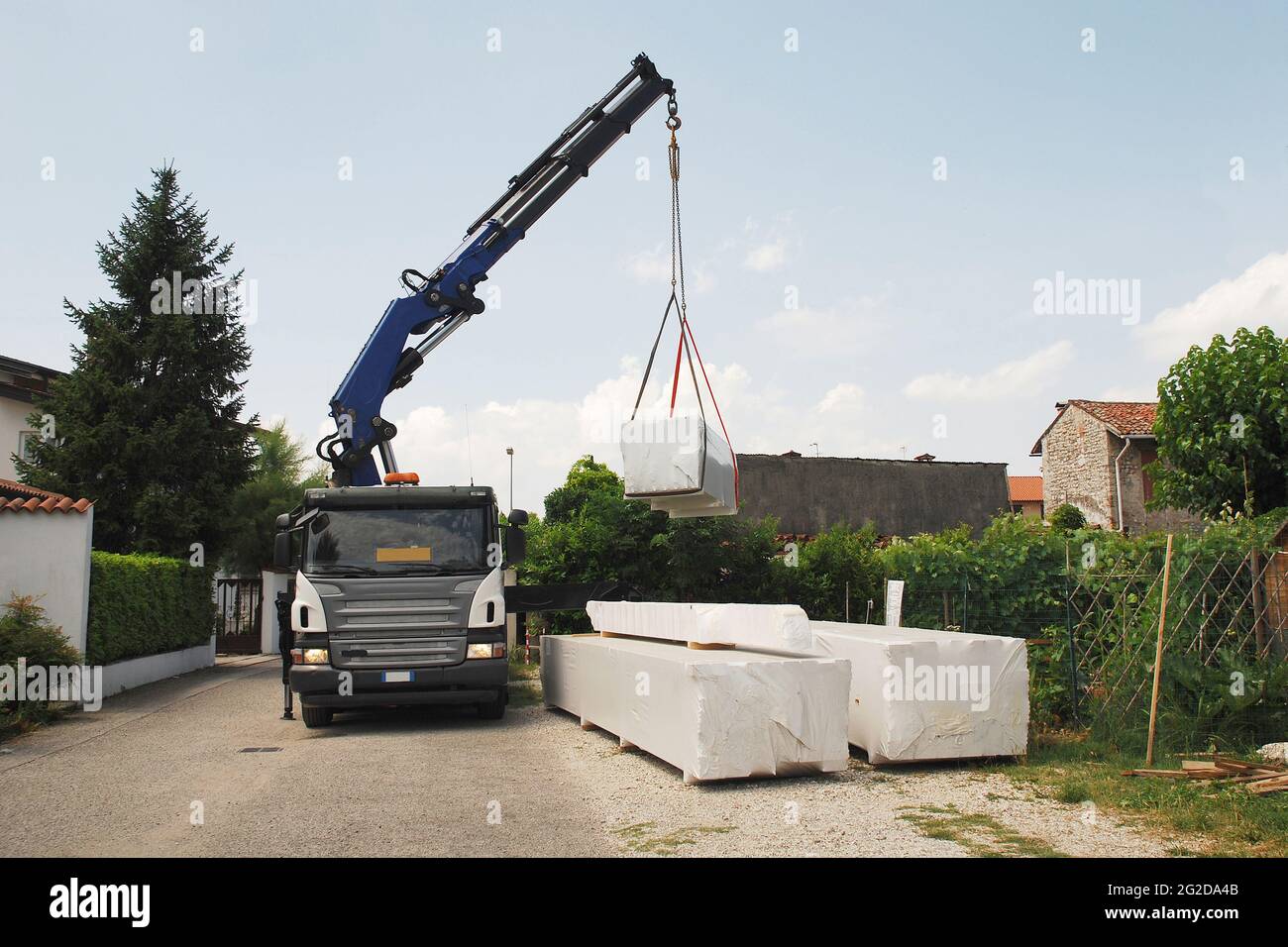 Un camion équipé d'une grue télescopique livre des colis contenant une ...
