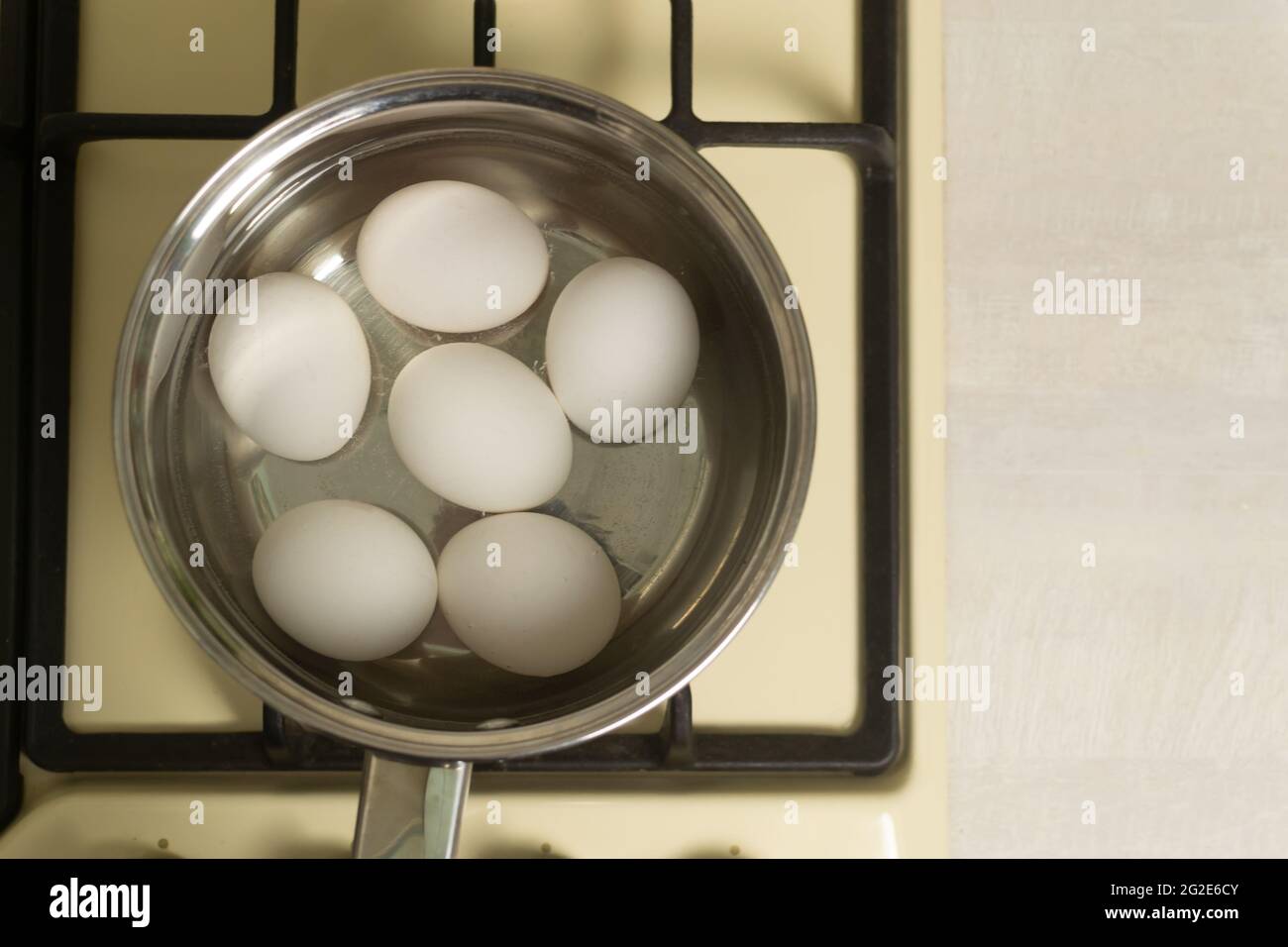 Les œufs De Poulet Blancs Sont Bouillis Dans Une Louche Avec Du Wate Sur La Cuisinière Dans La