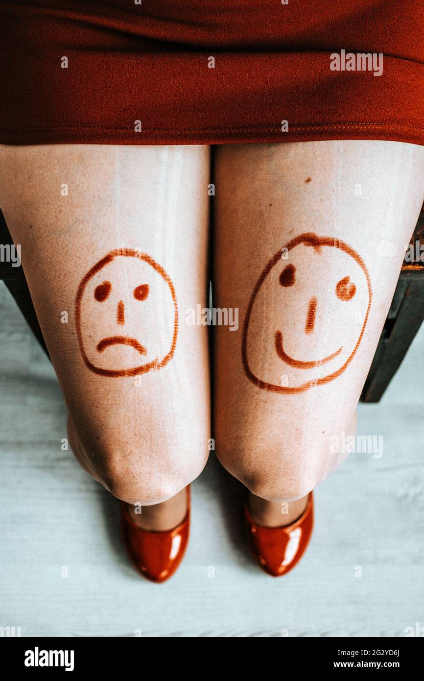 Les visages emoji dessinent sur les jambes de la femme avec un rouge à ...