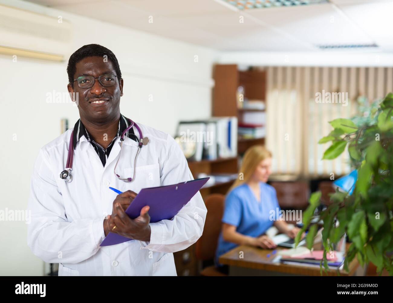 Un médecin afro-américain positif écrit des notes importantes sur un ...
