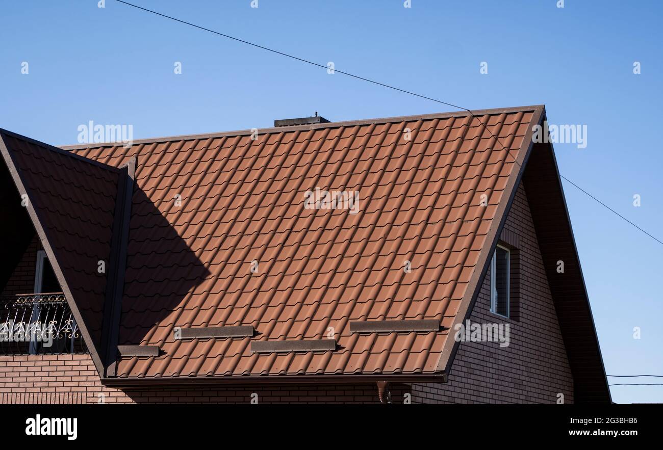 Toit à profil métallique ondulé brun installé dans une maison moderne ...