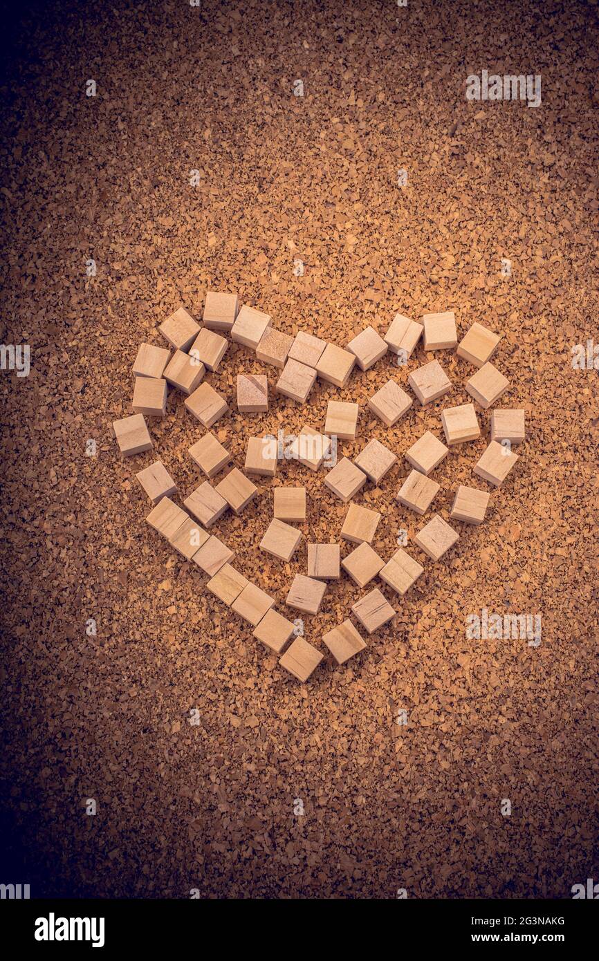 De petits cubes en bois forment un cœur ou un symbole de Saint-Valentin ...
