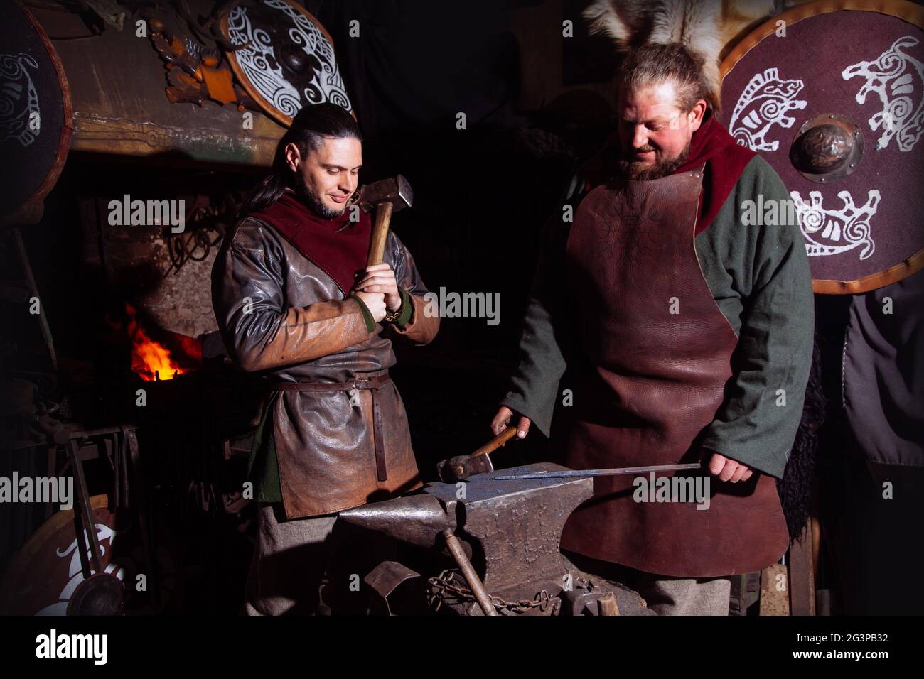 Armes et épées Viking forges dans la forge. Un homme en habits de ...