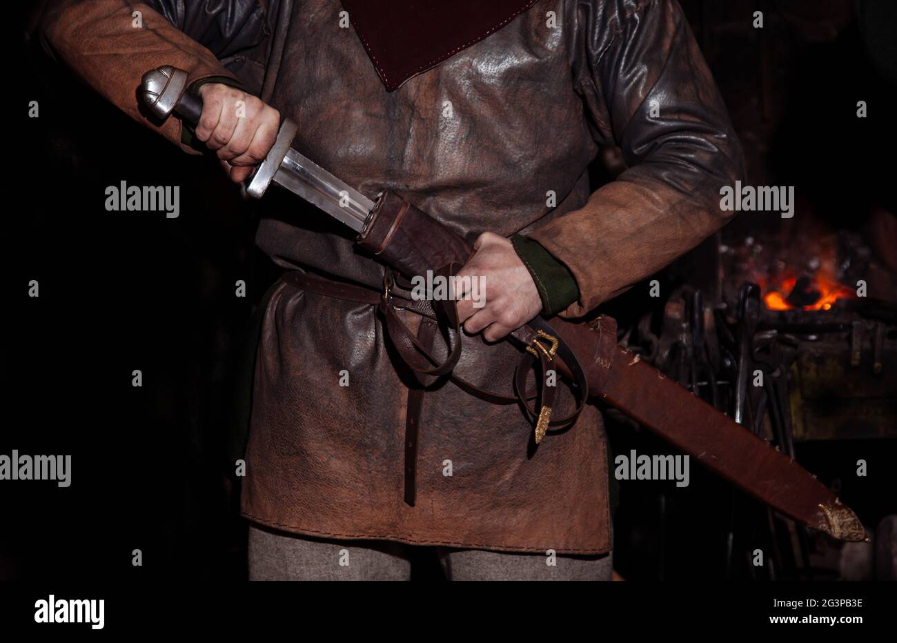 Armes et épées Viking forges dans la forge. Un homme en habits de ...