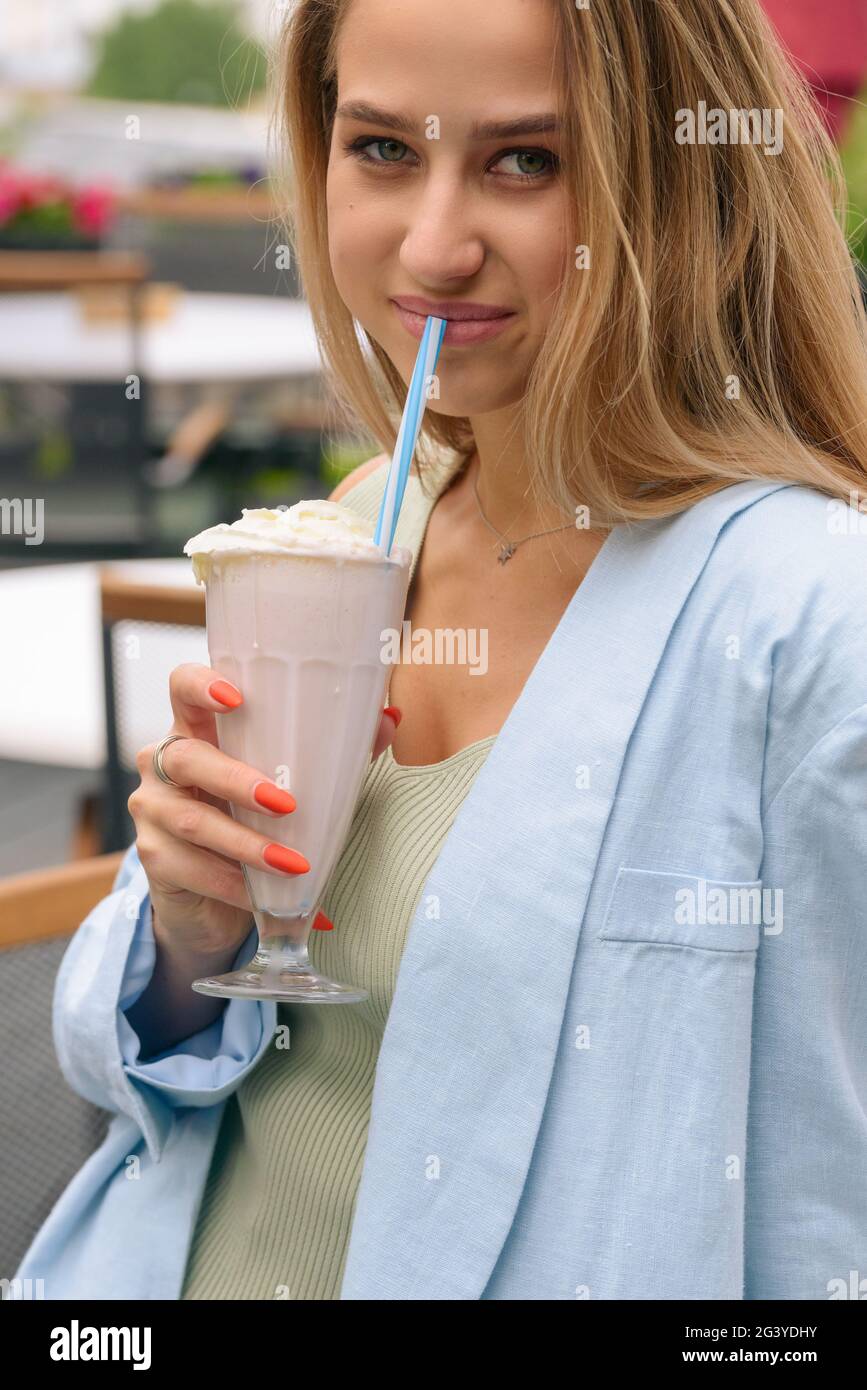 La main d'une femme tient un cocktail rafraîchissant dans un verre avec ...