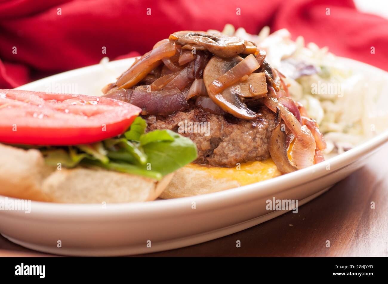 Gros plan d'un hamburger de bœuf avec oignons sautés, champignons et ...