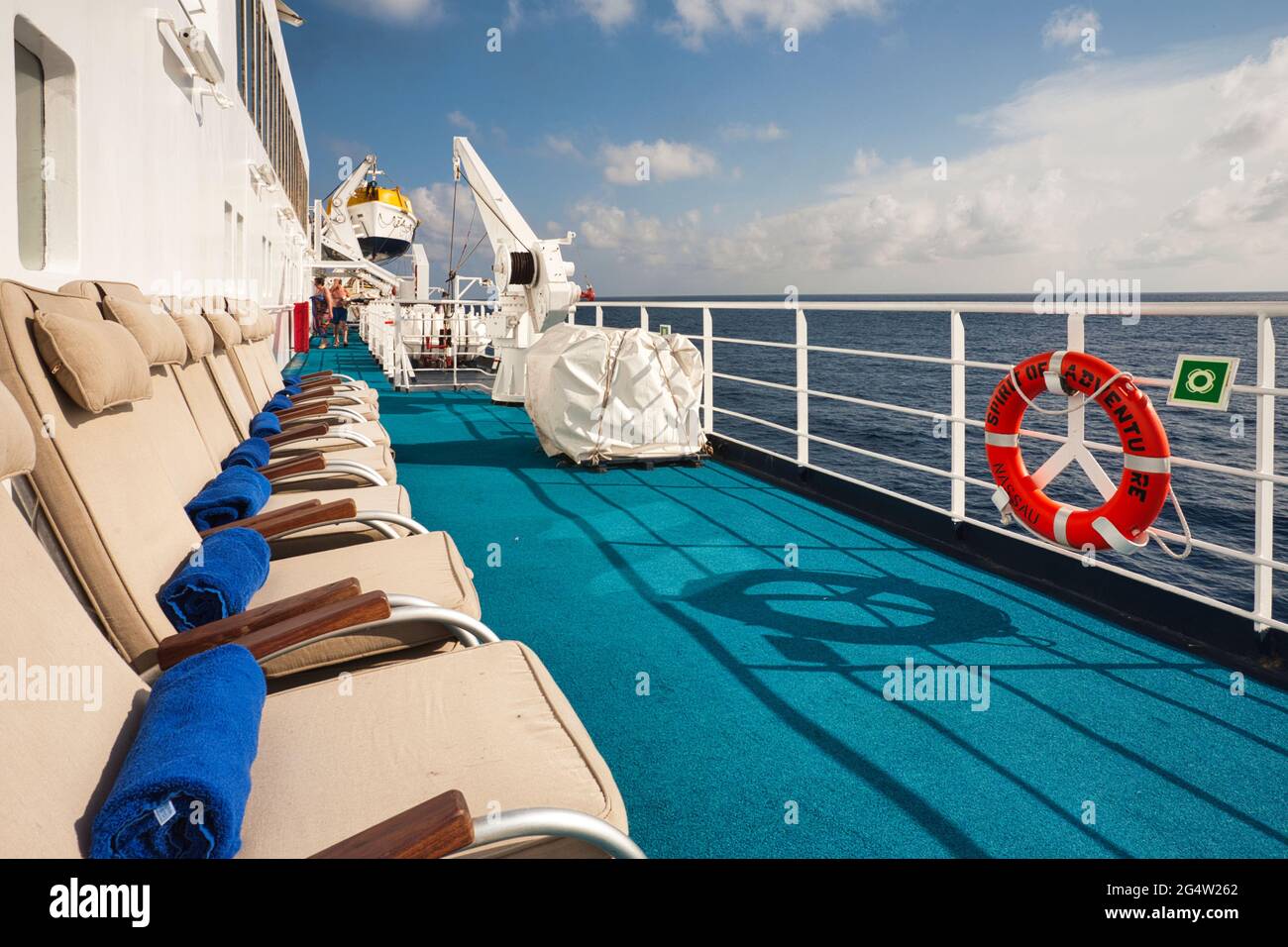 Le pont d'un bateau de croisière avec des serviettes sur les chaises ...