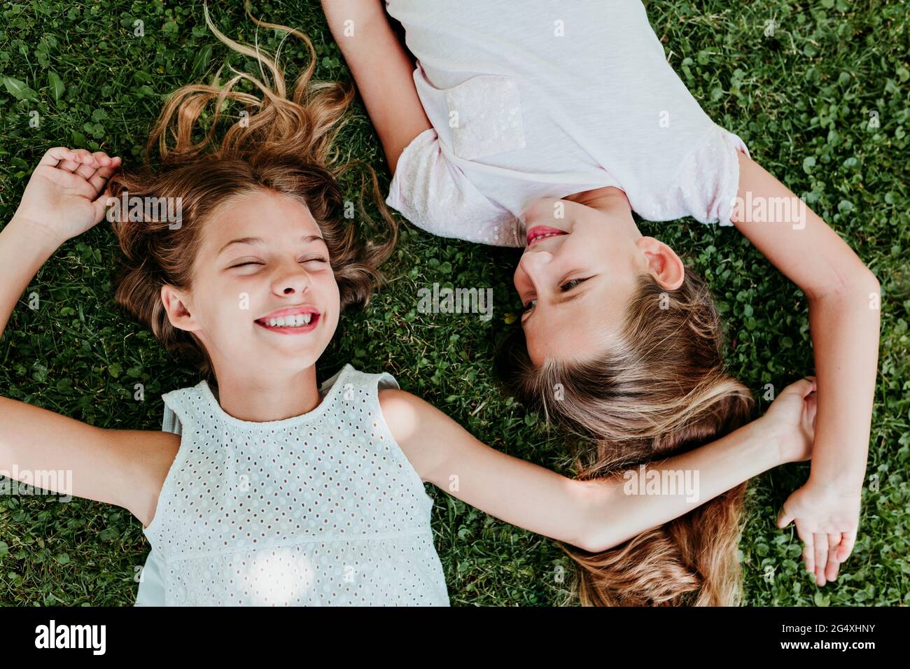 Joyeuses filles qui s'allonger sur l'herbe en été Photo Stock - Alamy