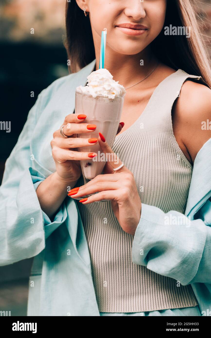 La main d'une femme tient un cocktail rafraîchissant dans un verre avec ...