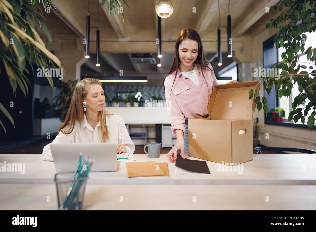 Jeune femme d'affaires tenant une boîte d'effets personnels sur le ...