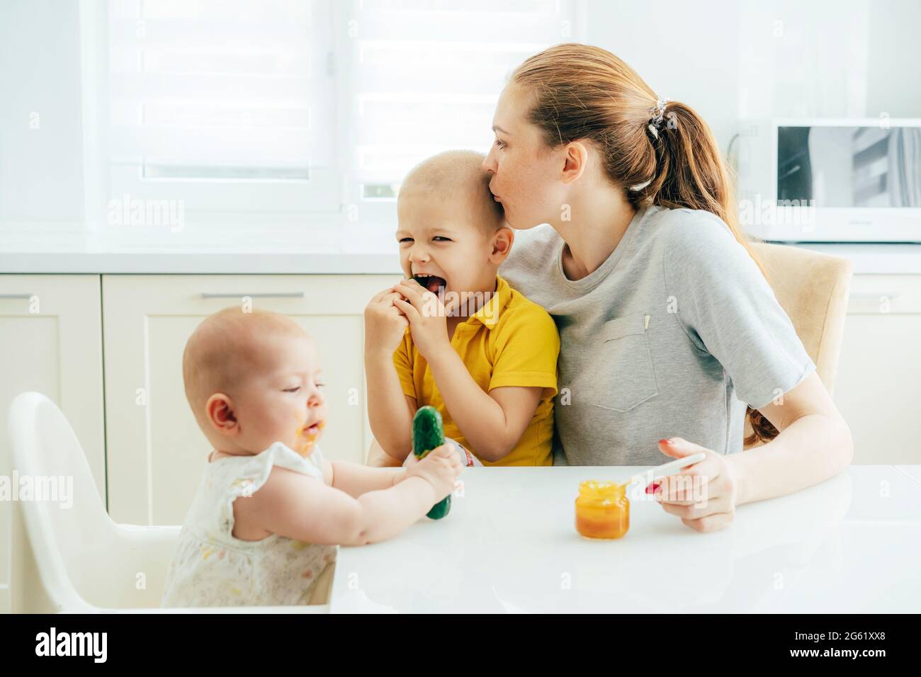 Une maman heureuse passe du temps avec les enfants dans la cuisine pour ...