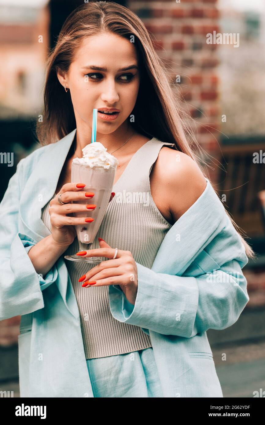La main d'une femme tient un cocktail rafraîchissant dans un verre avec ...