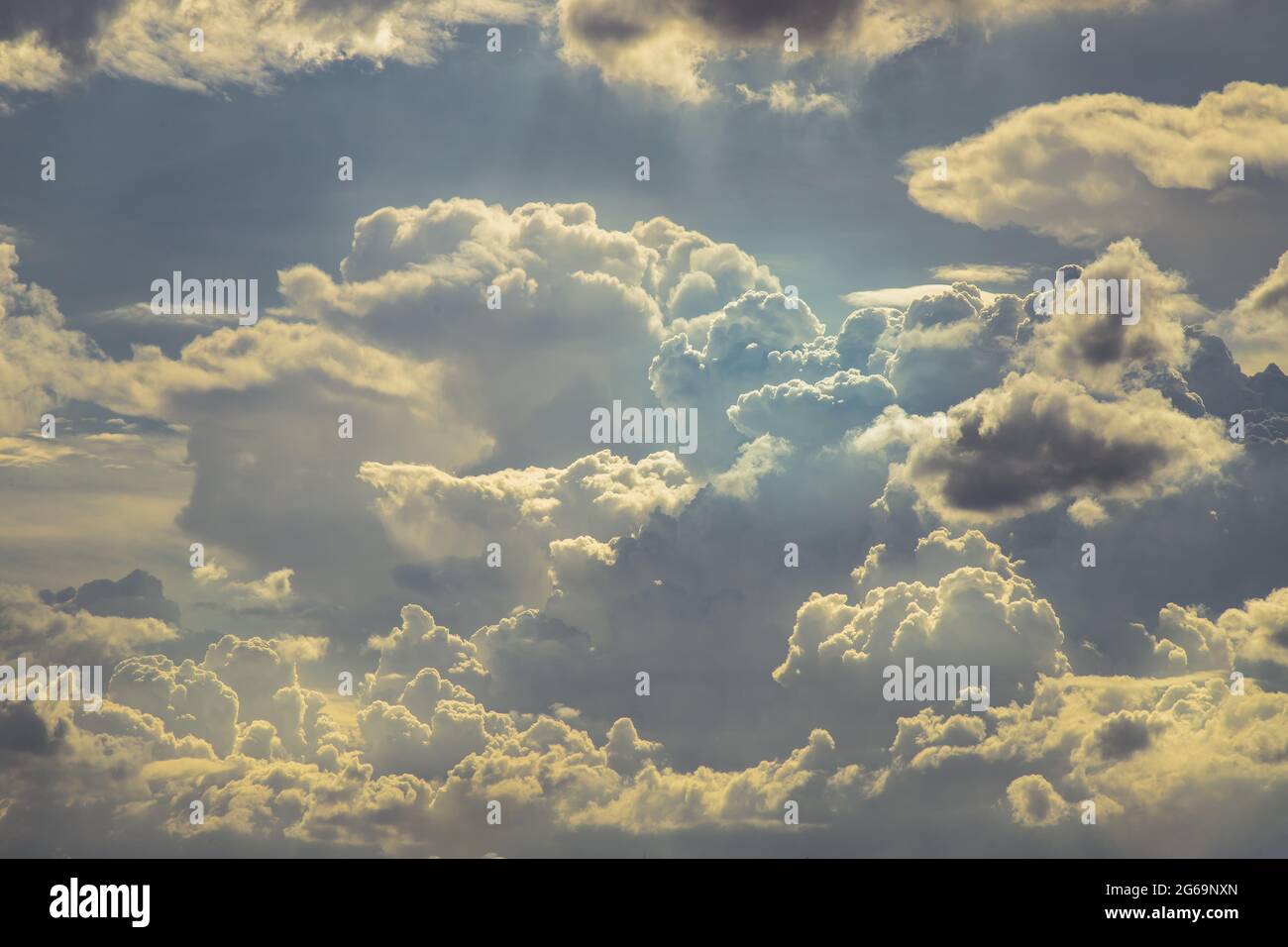 Le soleil brille à travers les nuages dans le ciel. La forme des nuages ...