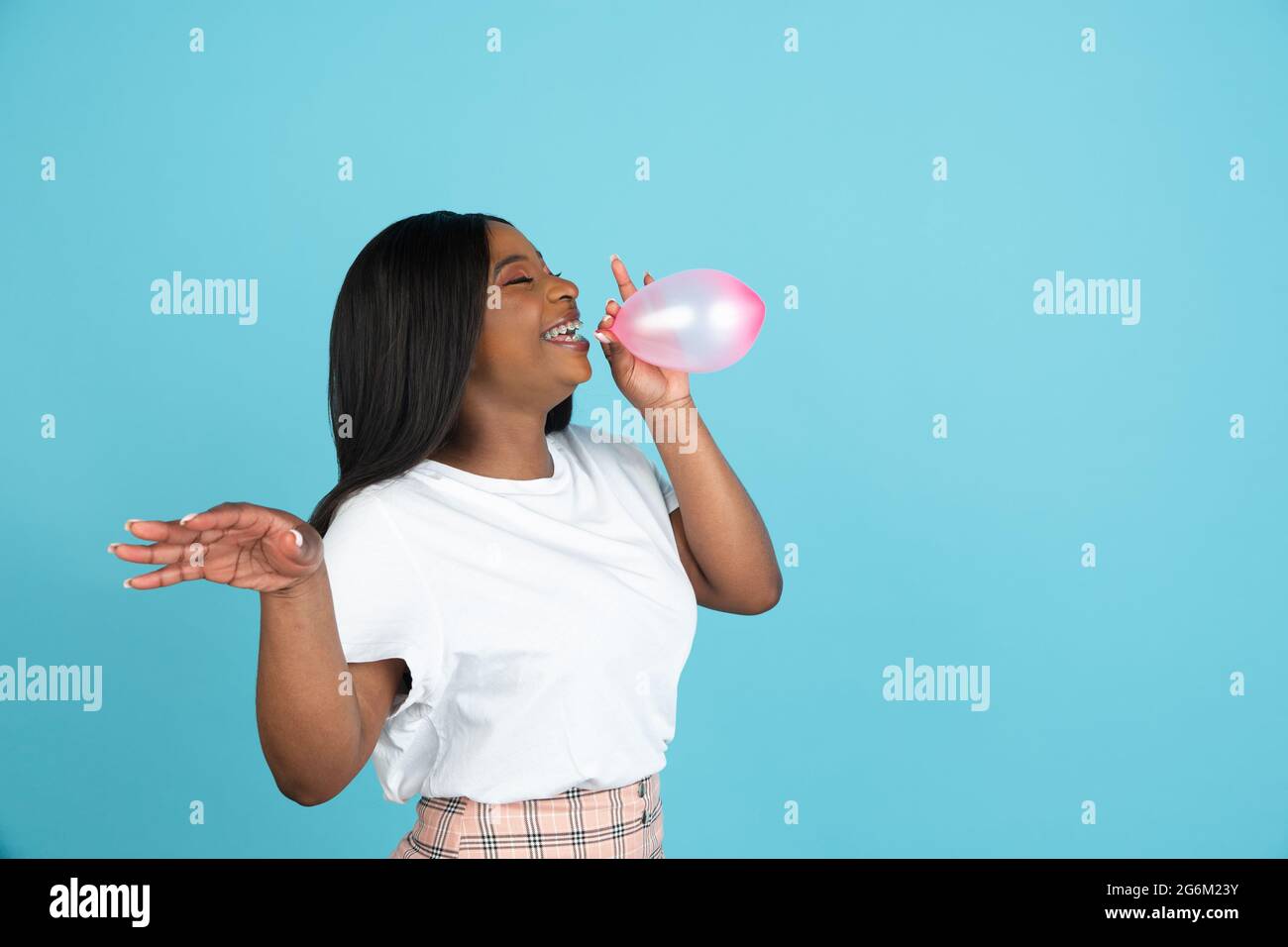 Amuse-toi bien. Mignon, drôle de jeune femme africaine isolée sur fond ...