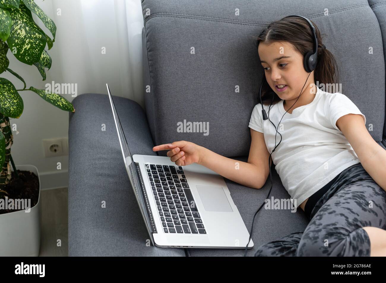 Enfant petite fille avec un ordinateur portable à la maison. Un petit ...